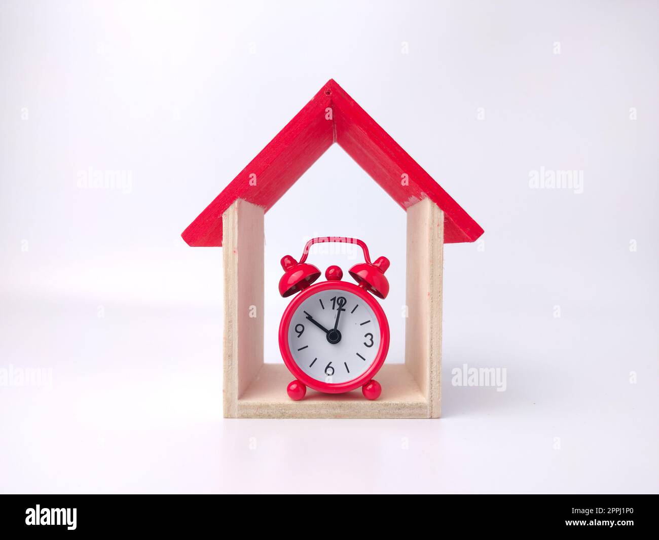 Alarm clock and toy house on a white background Stock Photo - Alamy