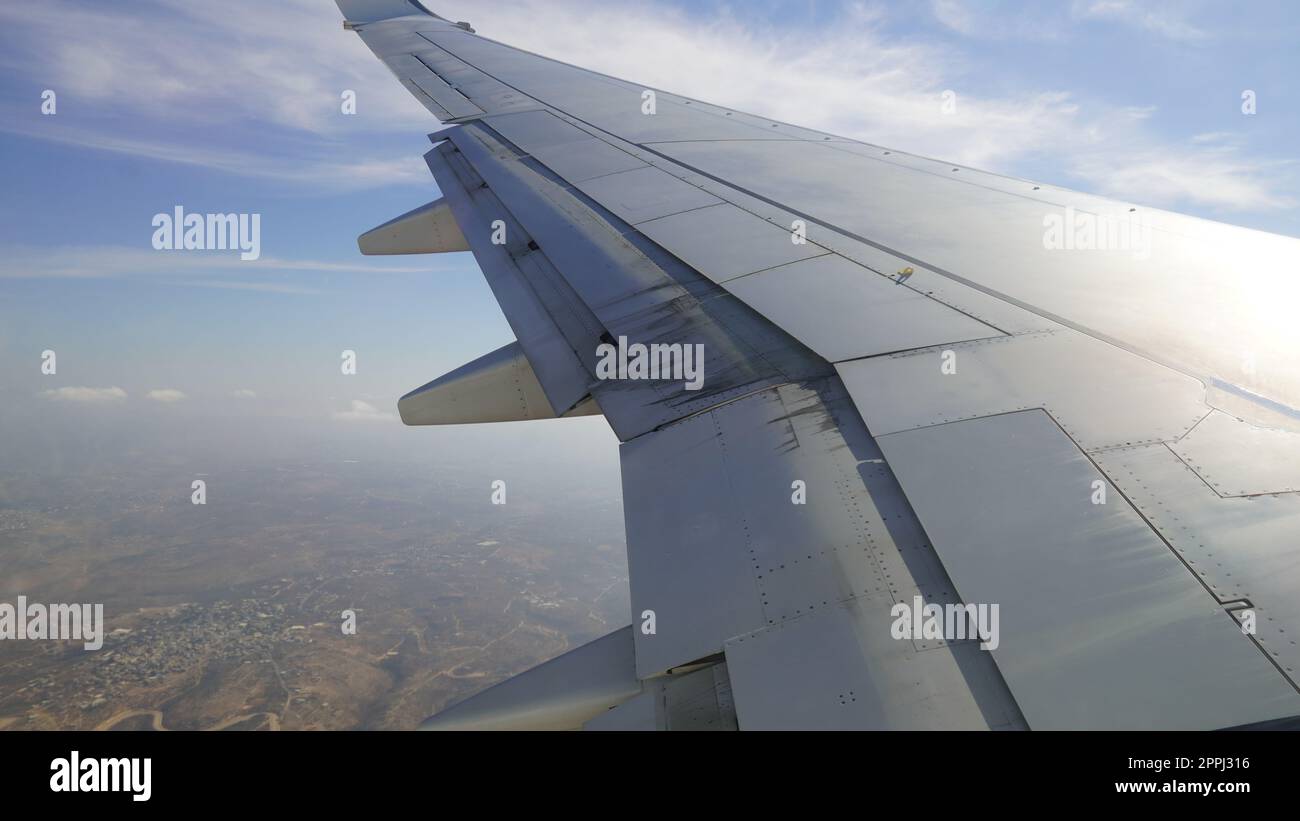 Wing of an airplane flying over Israel, Passenger s view. Looking through the window of a plane ...