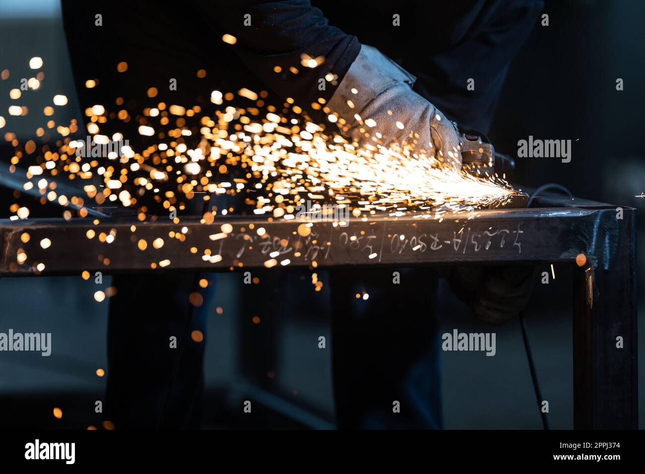 Man working on iron with grinder. Man at work. Sparkles and fire from ...
