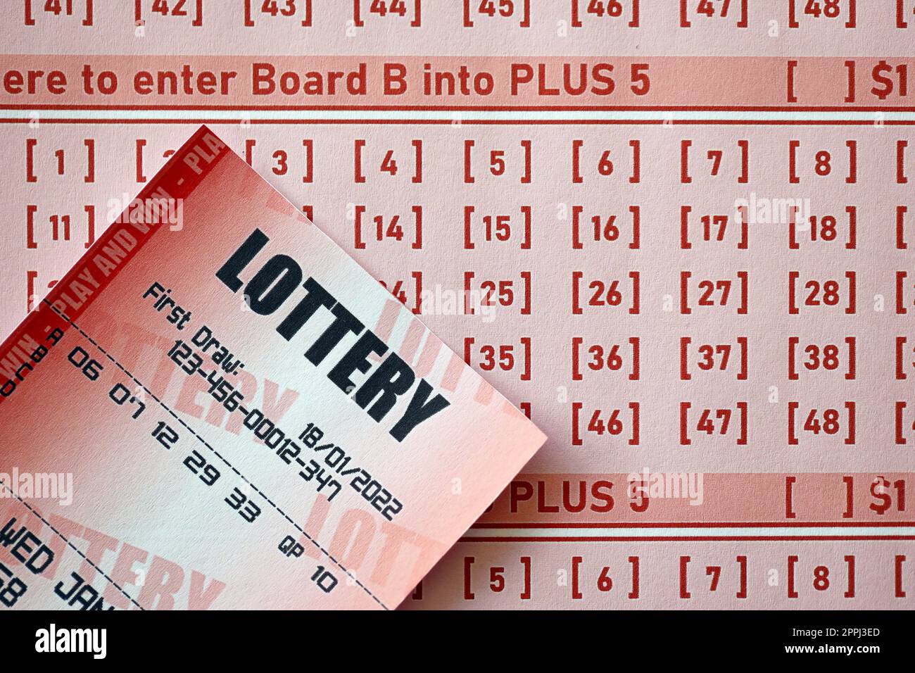 Red lottery ticket lies on pink gambling sheets with numbers for ...