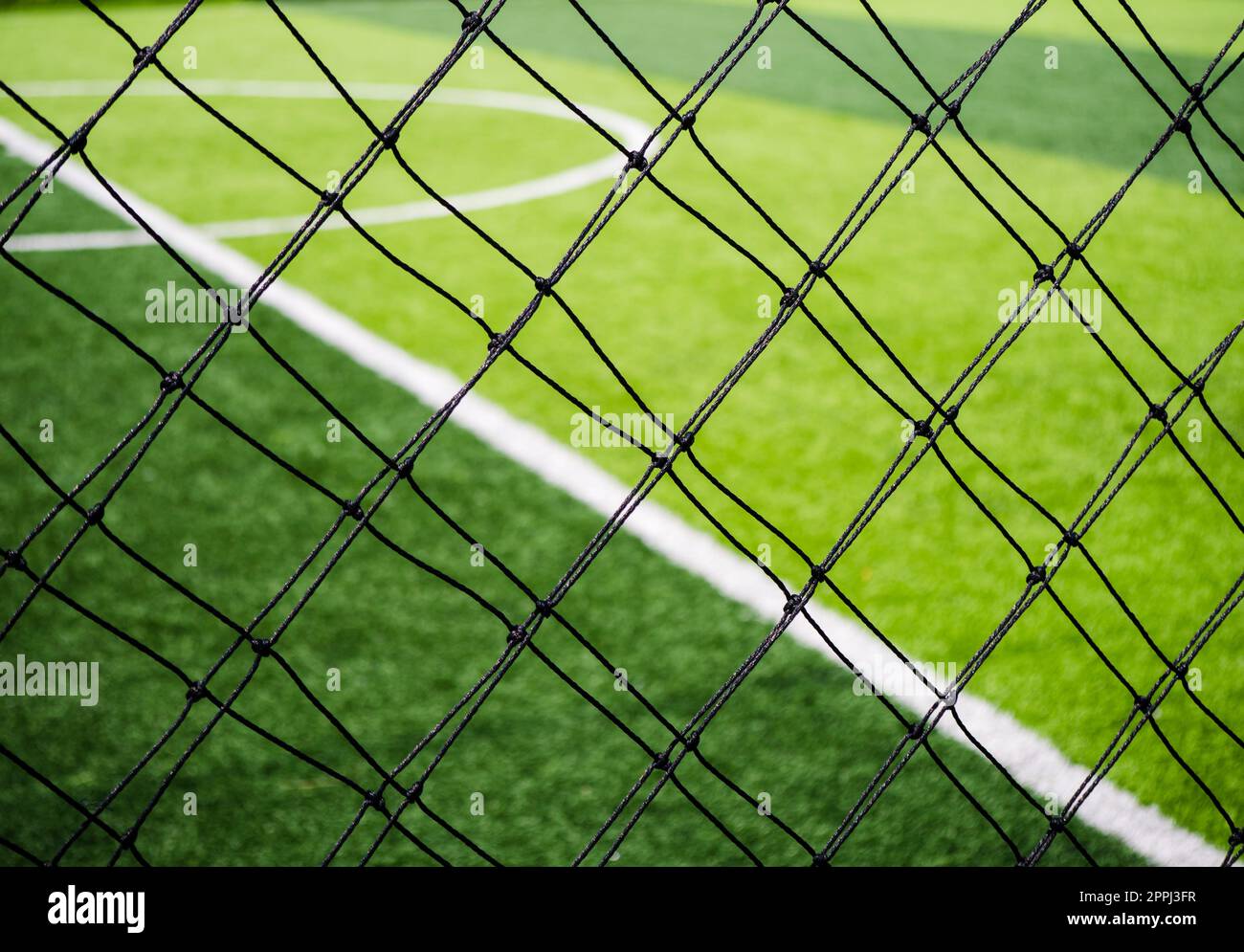 Soccer field, corner side, made from synthetic lawn, behind the net ...