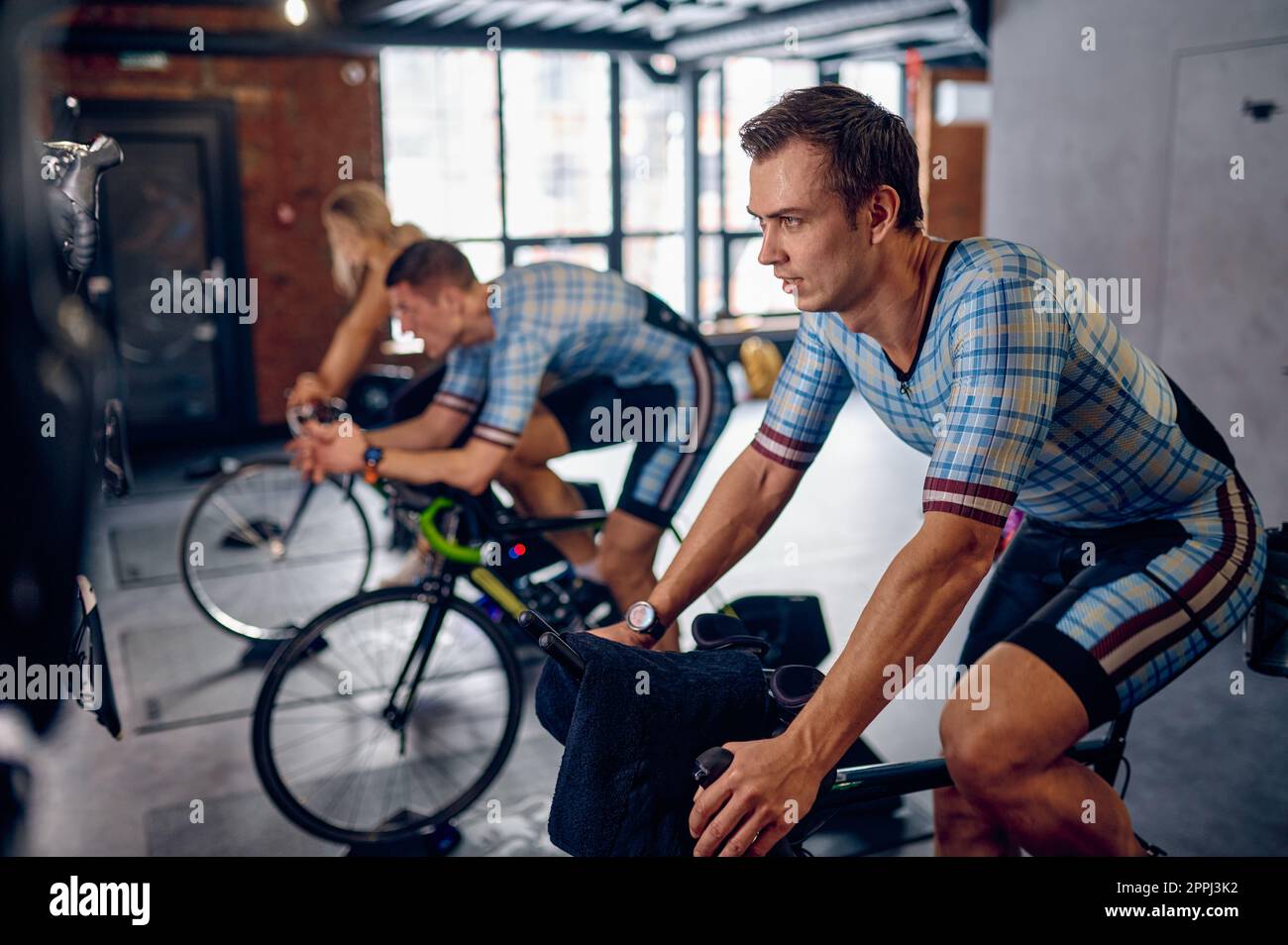 Man cycling on bike machine trainer at gym sport club Stock Photo - Alamy