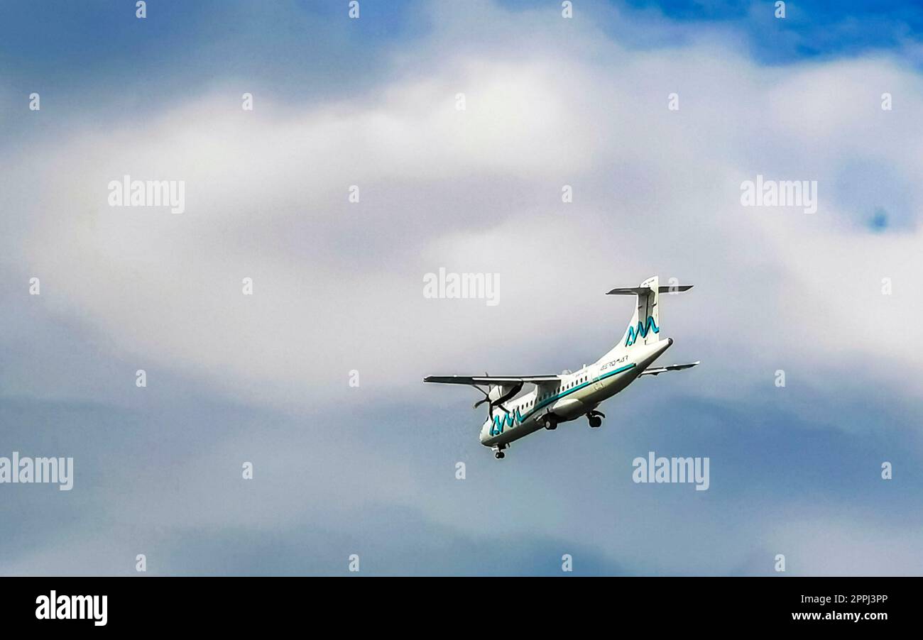 Plane flies over Puerto Escondido Mexico with blue sky Stock Photo - Alamy