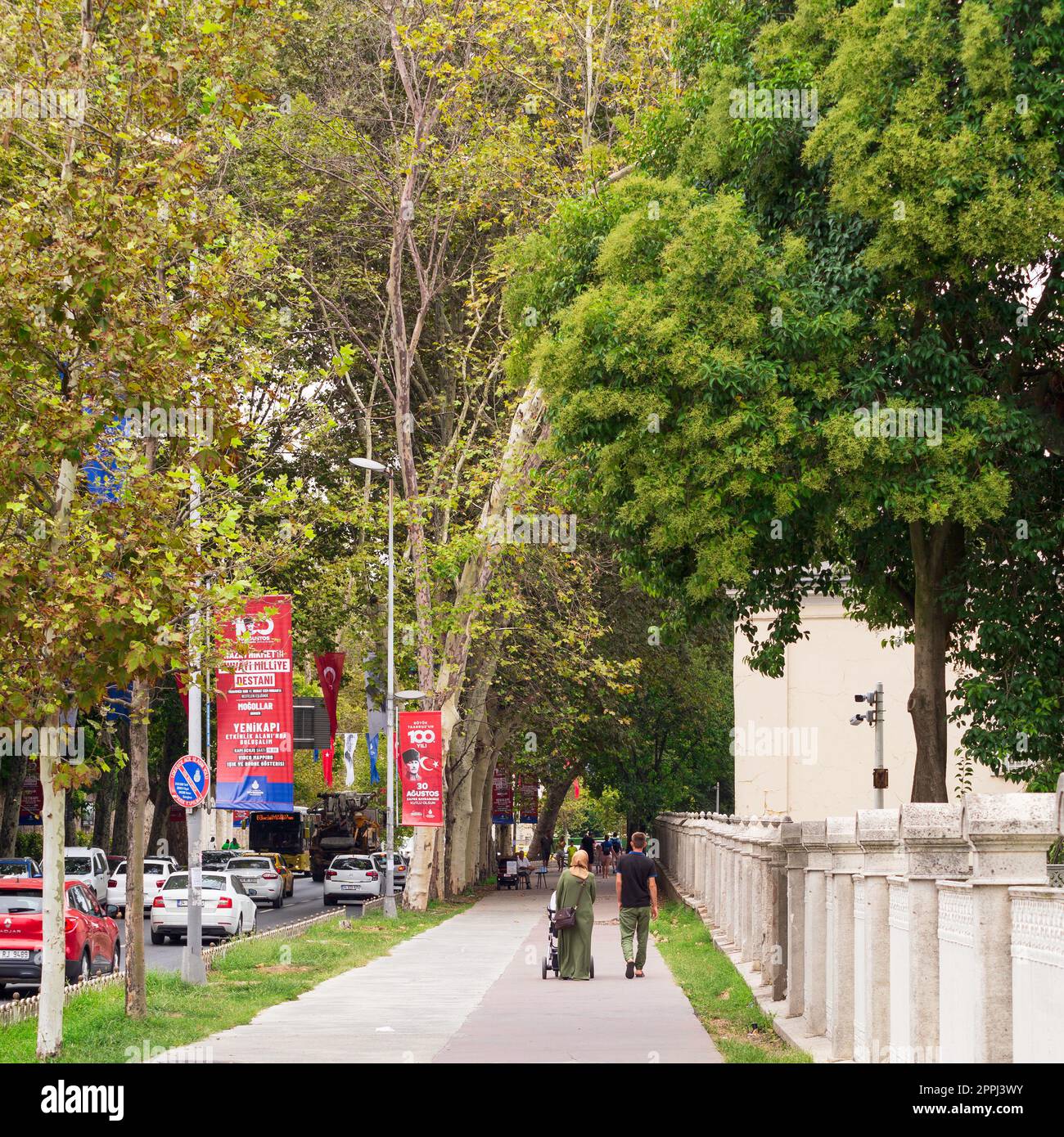 Pedestrians walking in a passage with huge trees in Gulhane Park in ...