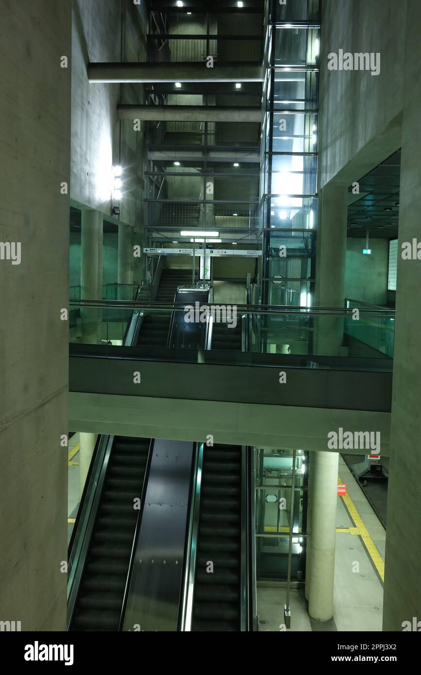 Escalator, concrete, and glass in a futuristic underground station in ...