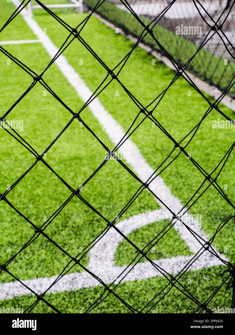 Soccer field, corner side, made from synthetic lawn, behind the net ...