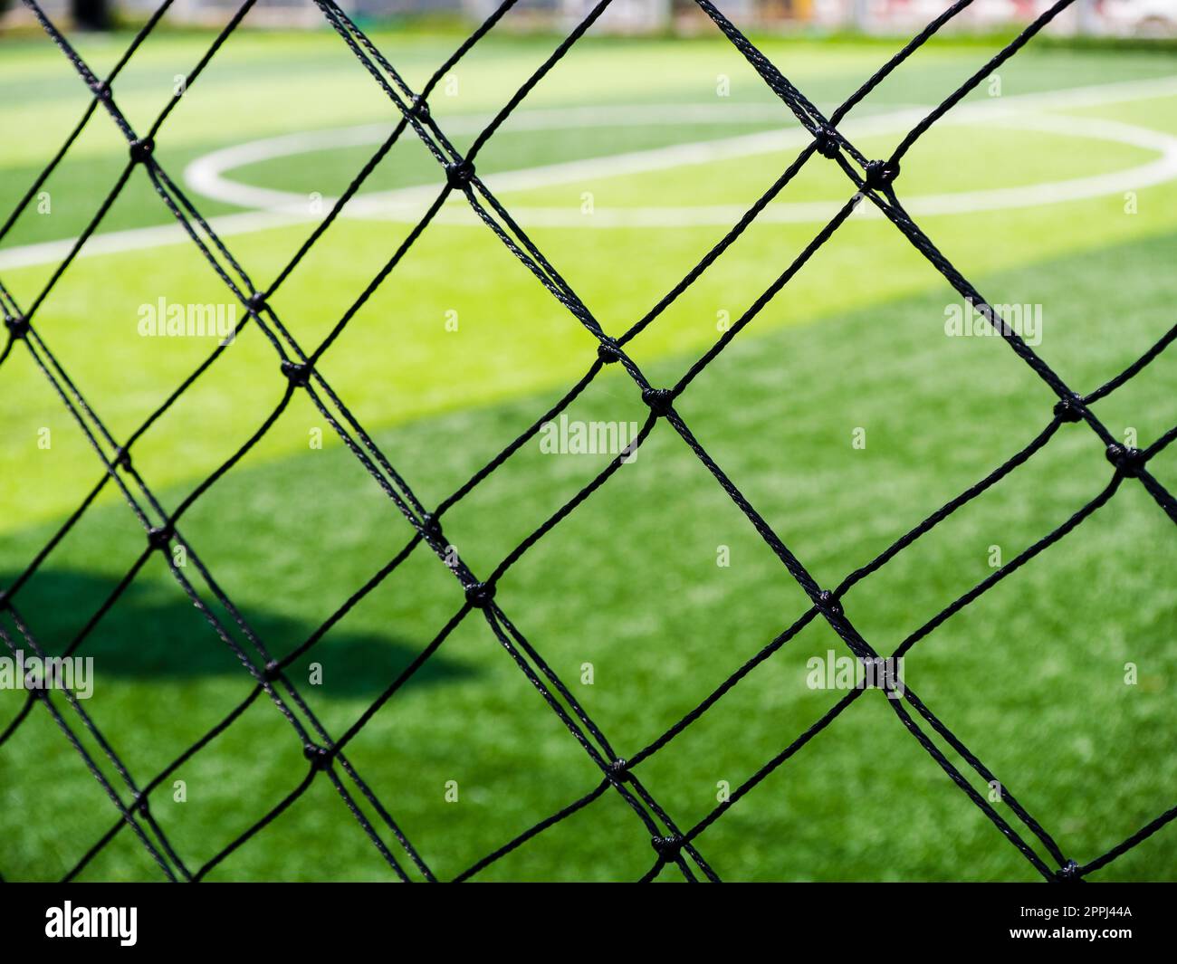 Soccer field, corner side, made from synthetic lawn, behind the net ...