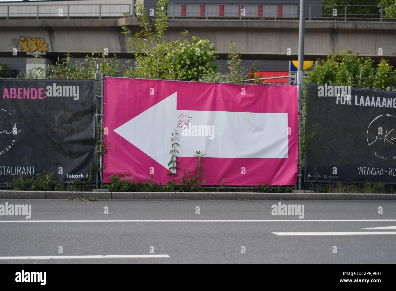 Billboard with a pink poster and a white arrow pointing left Stock ...