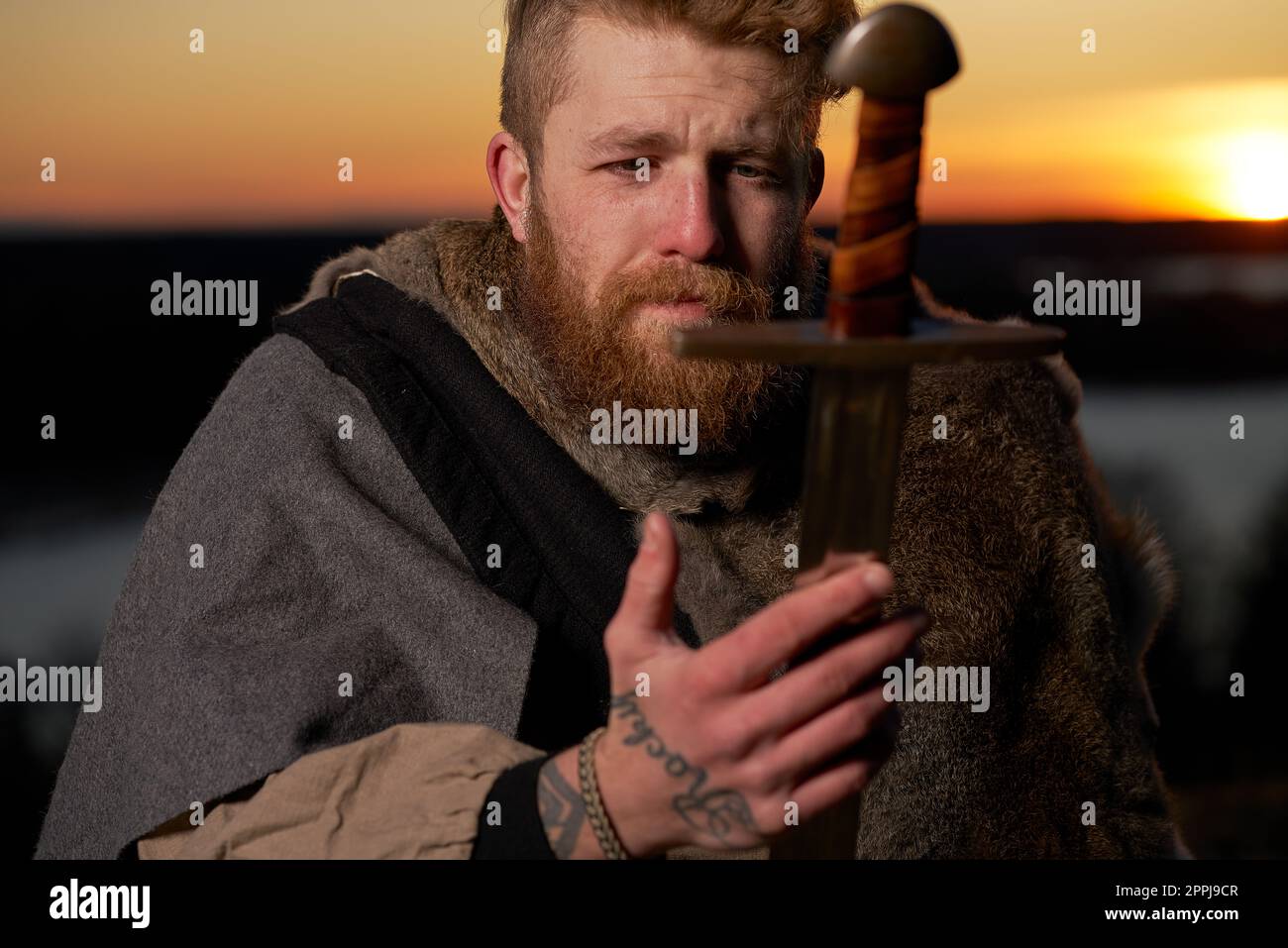 medieval man looking at his sword Stock Photo - Alamy