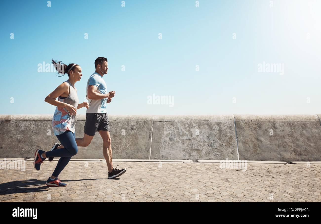 Keep moving forward. Full length shot of a young couple out for a run ...