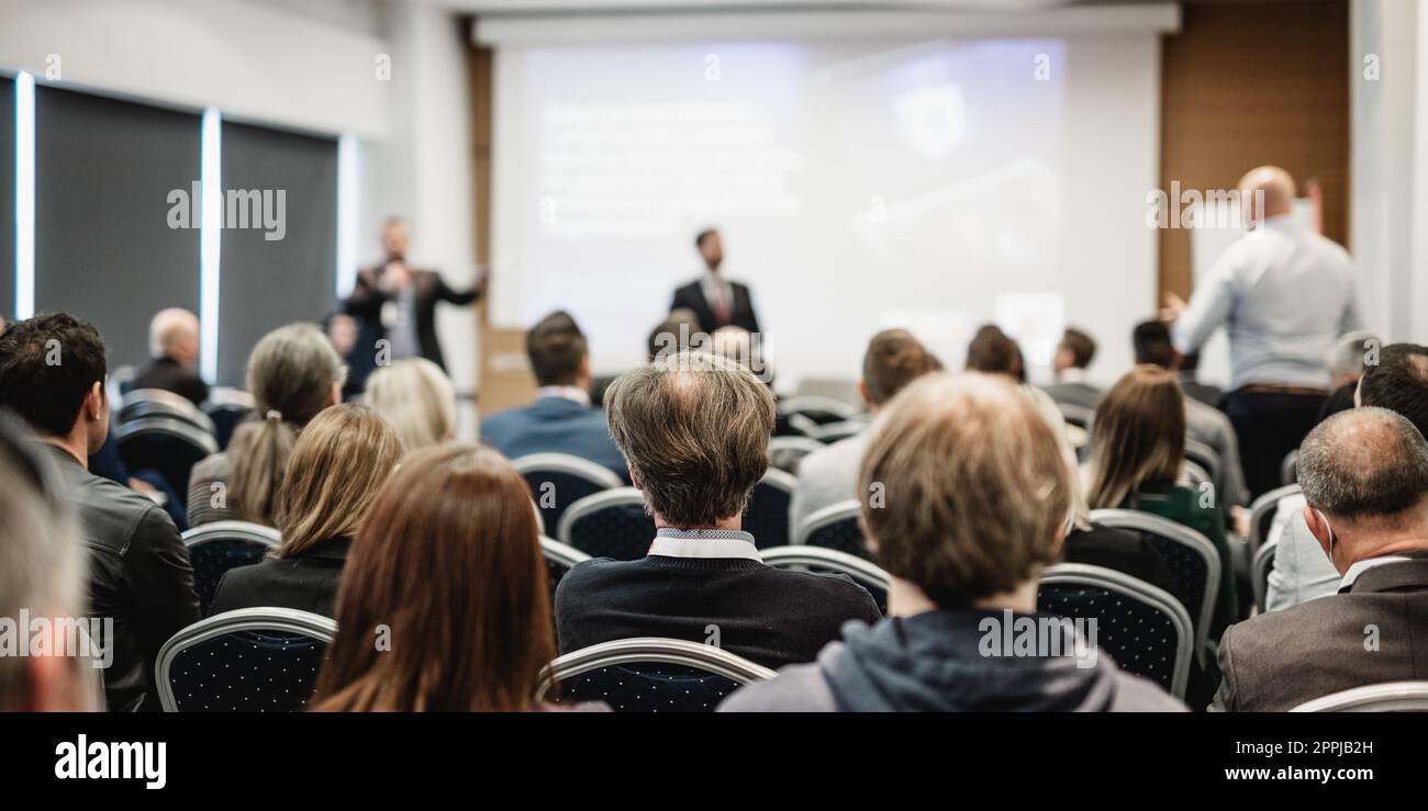 I have a question. Group of business people sitting in conference hall ...