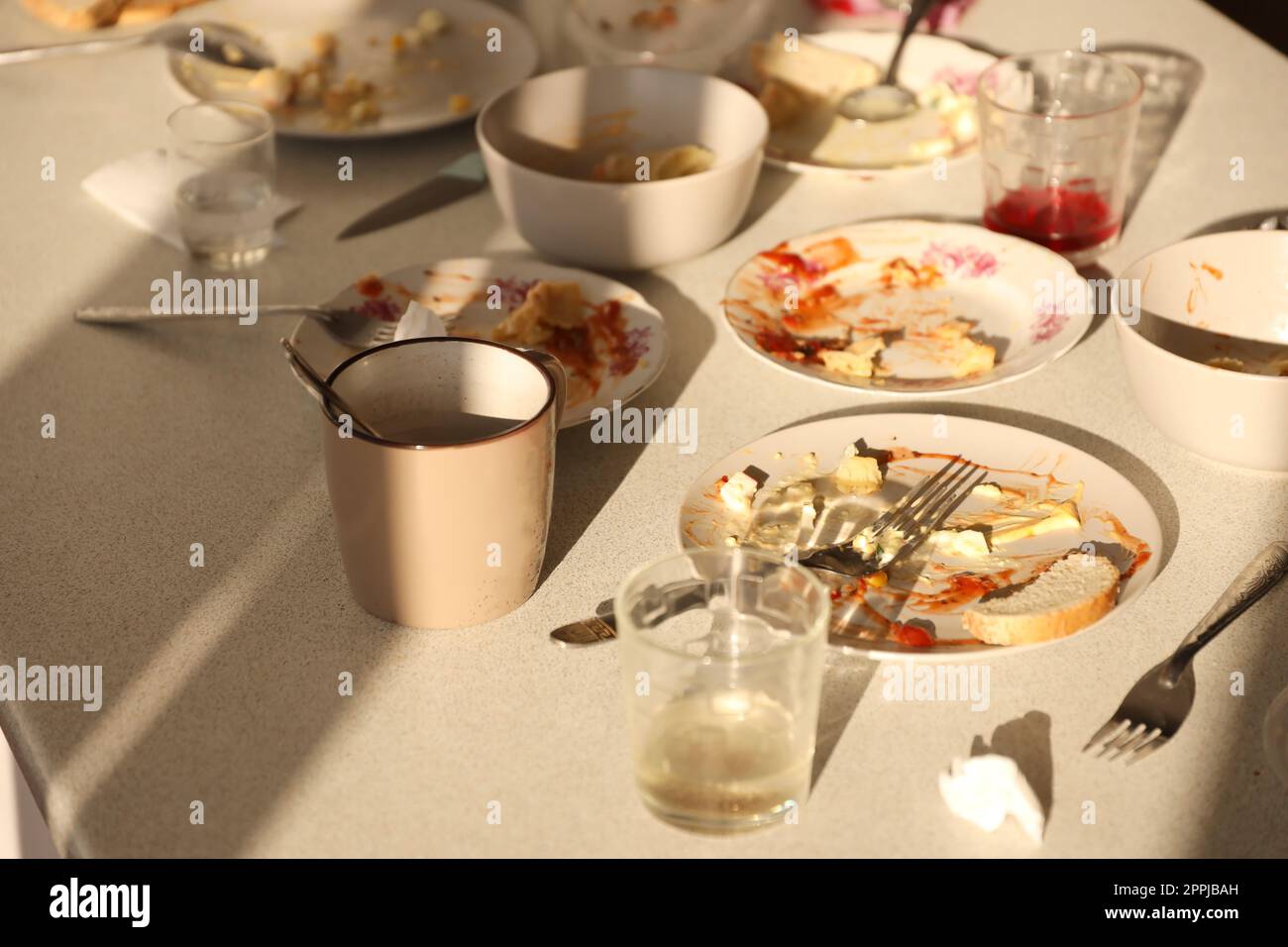 Empty dirty plates with spoons and forks on the table after meal ...
