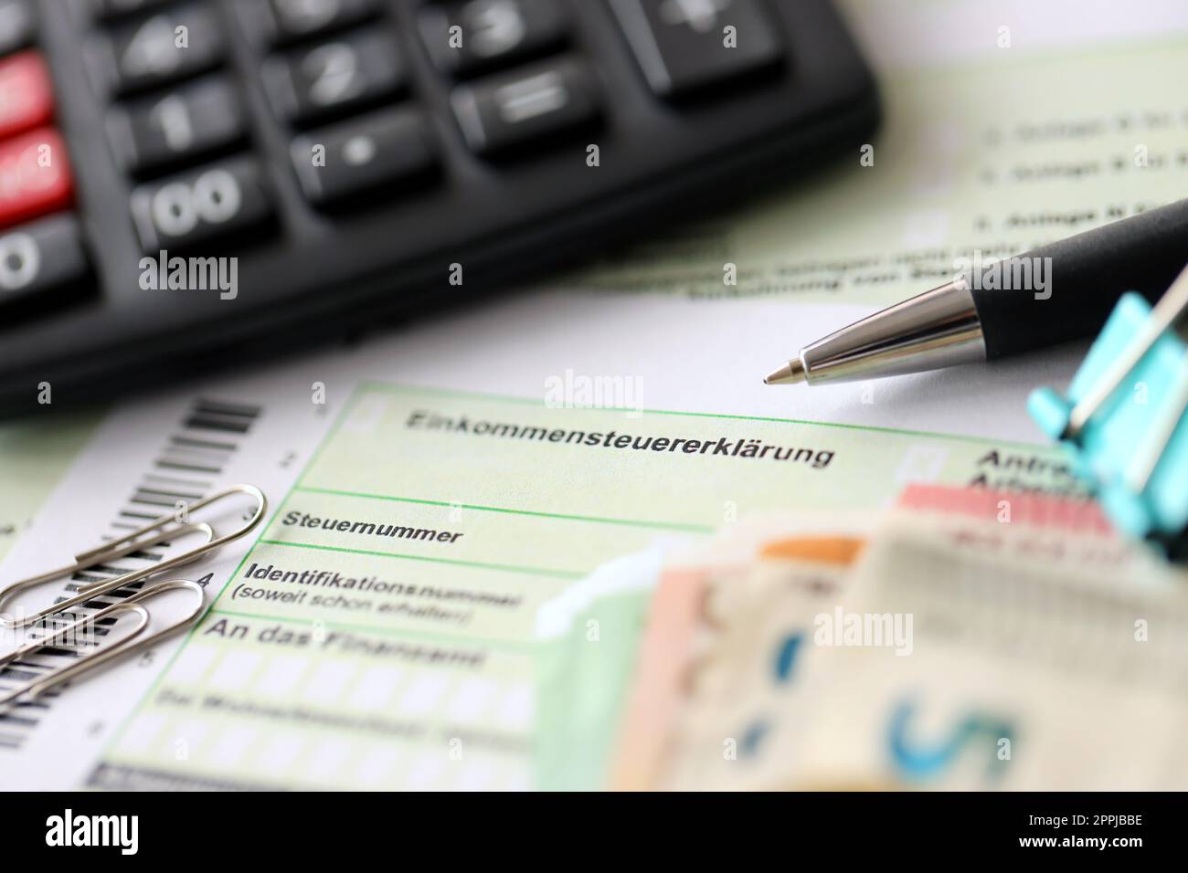 German income tax return form with pen and european euro money bills ...