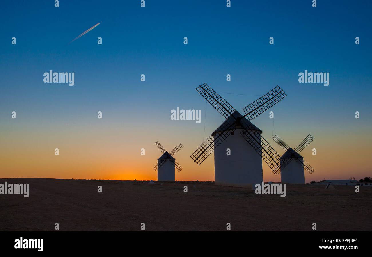 Airliner flying over windmills of Campo de Criptana, Spain Stock Photo ...