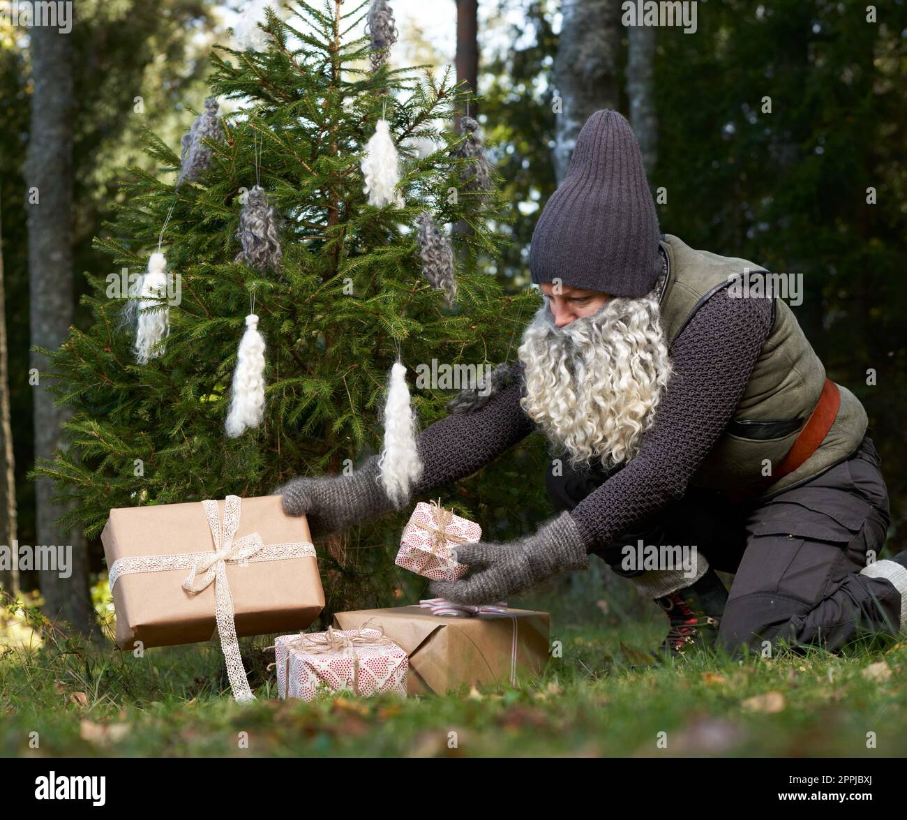 Scandinavian santa delivering christmas presents wearing a grey outfit ...