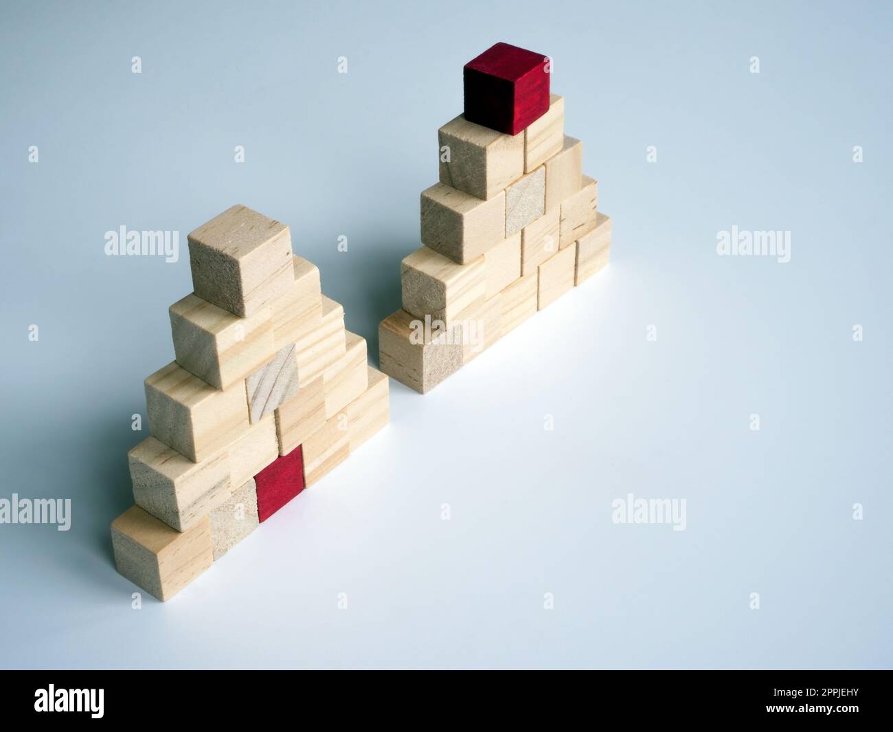 Two pyramids of cubes side by side. Difference between leader and manager concept Stock Photo ...