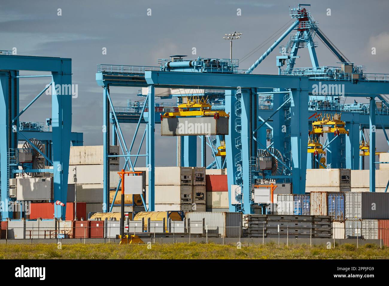 Cranes for cargo containers in freight terminal Stock Photo - Alamy