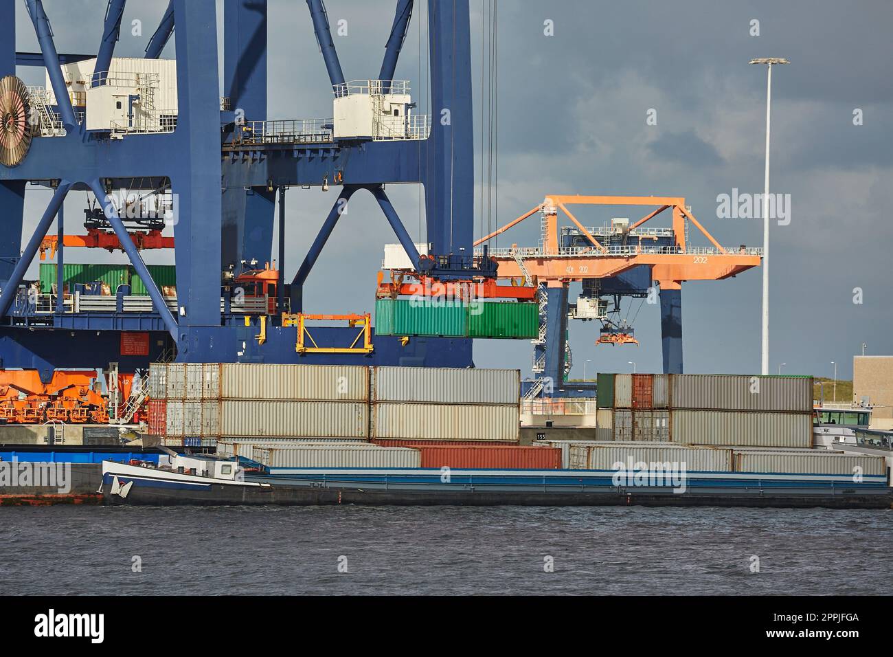 Loading containers on a ship Stock Photo - Alamy