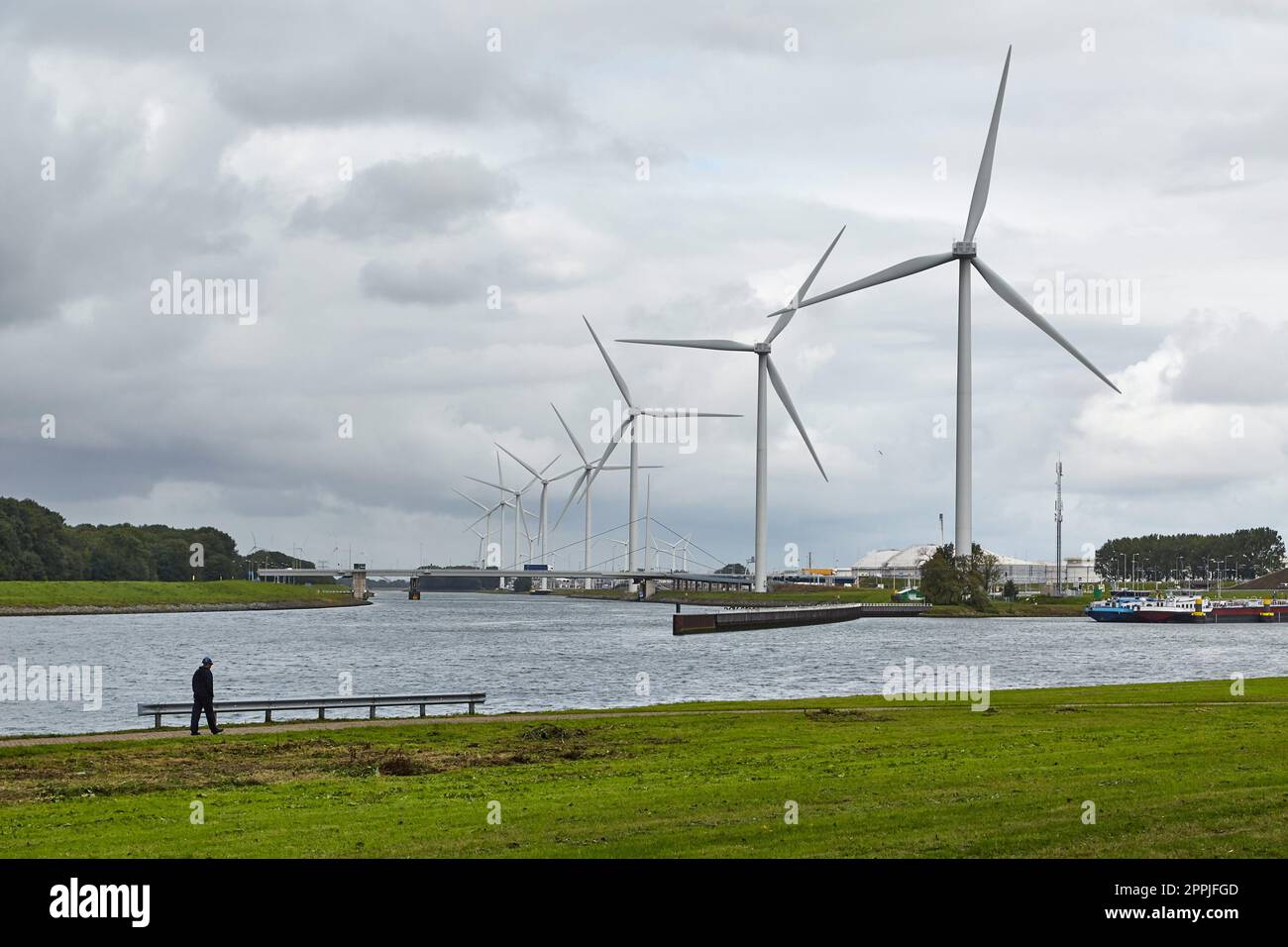 Wind turbines in a line alongindustrial canal in the port of Rotterdam ...