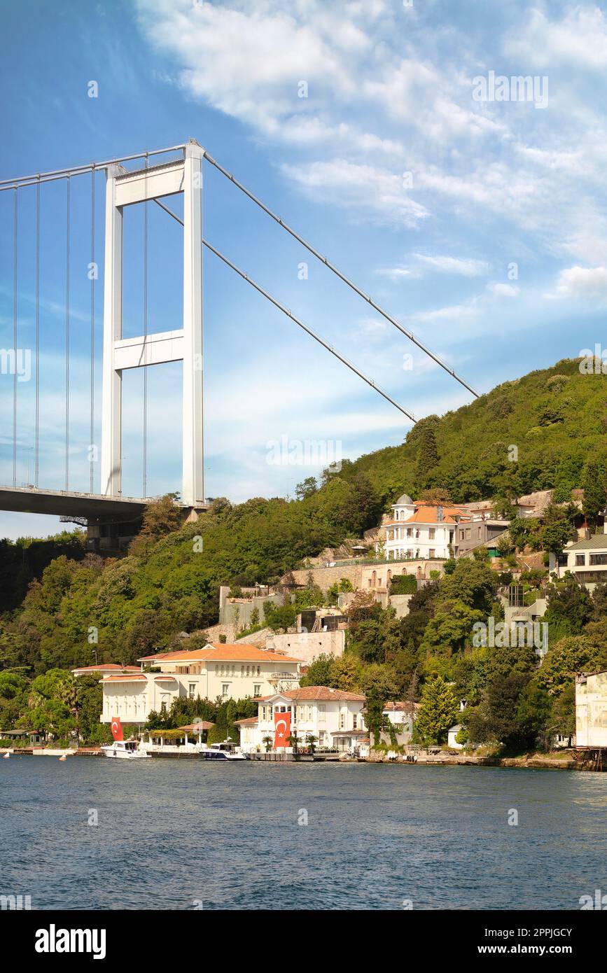 Traditional waterfront houses, Bosphorus bridge, and green hill with ...