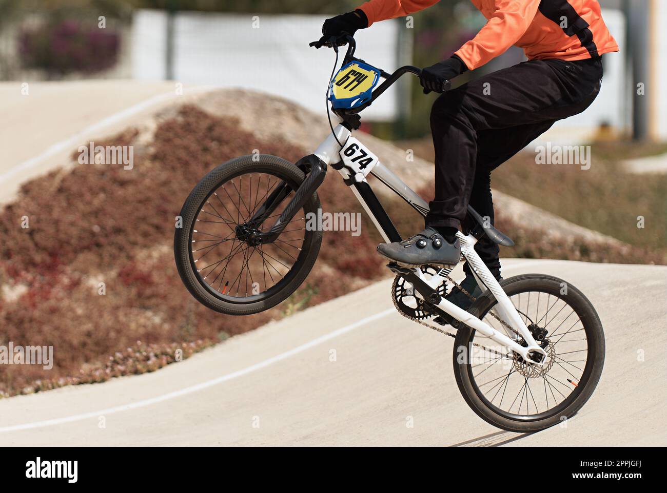Young boy jumping with his BMX bike at pump track. BMX racing track ...