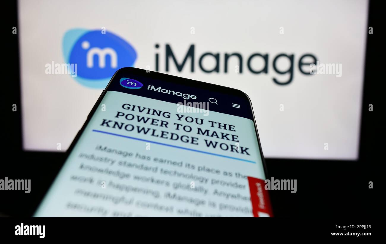 Mobile phone with website of US software company iManage LLC on screen in front of business logo ...