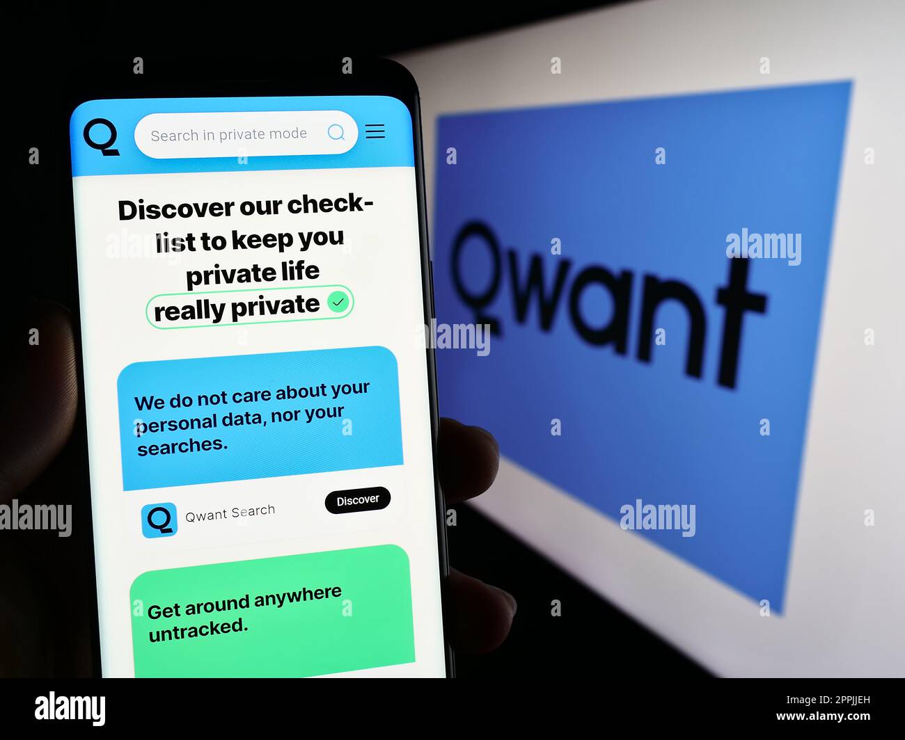 Person holding cellphone with web page of French search engine company ...