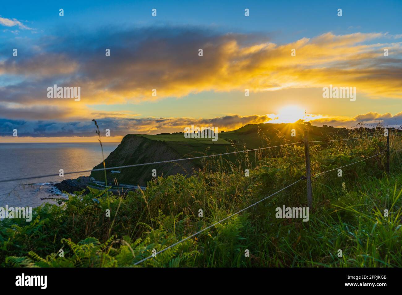 Sunrise sun over the green hills by Atlantic Ocean. Basque country ...