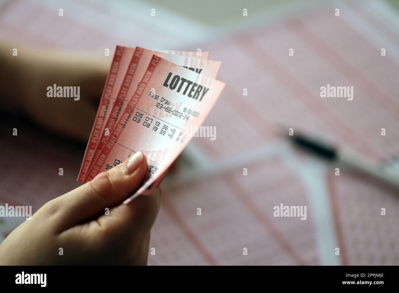 Filling out a lottery ticket. A young woman holds the lottery ticket ...