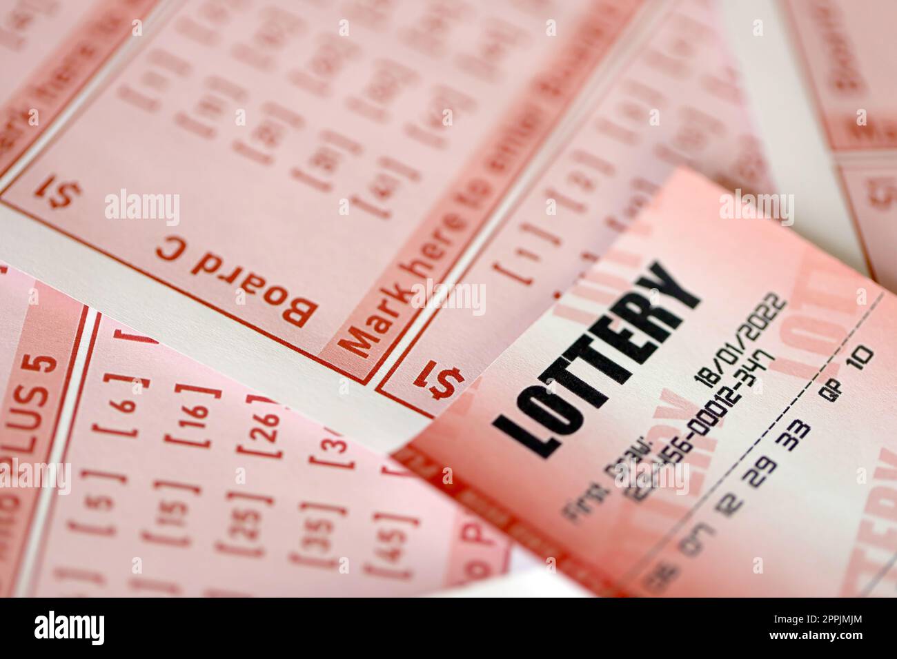 Red lottery ticket lies on pink gambling sheets with numbers for ...