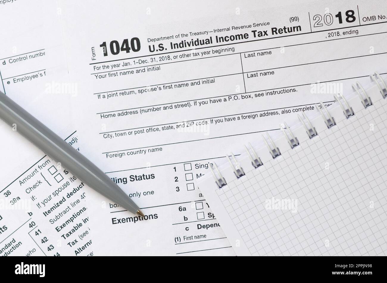 The pen and notebook is lies on the tax form 1040 U.S. Individual ...