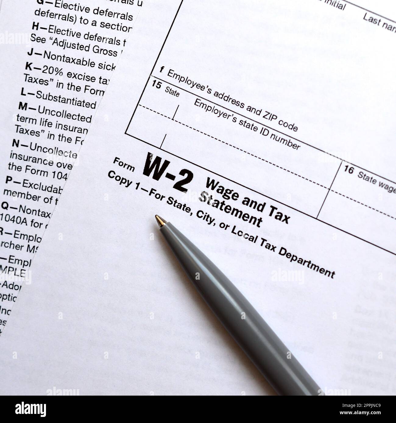 The pen lies on the tax form W-2 Wage and Tax Statement. The time to ...
