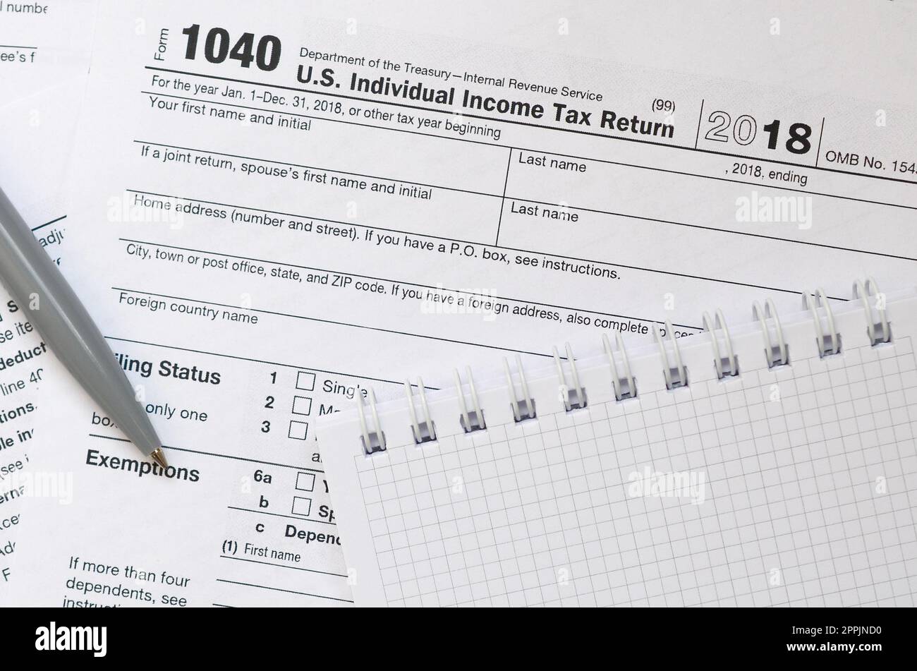 The pen and notebook is lies on the tax form 1040 U.S. Individual ...