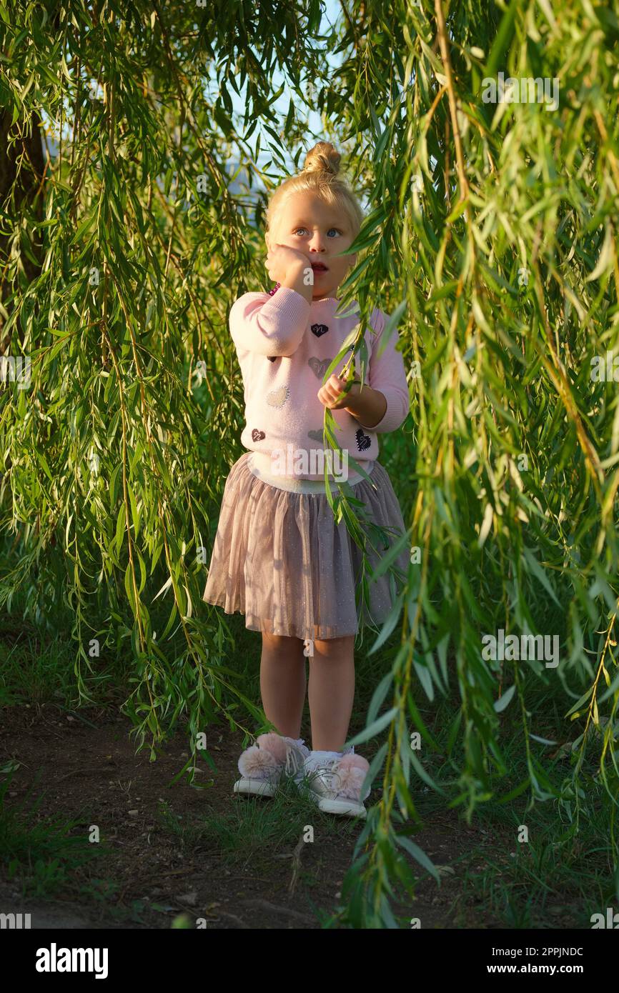 Little child under willow tree Stock Photo - Alamy