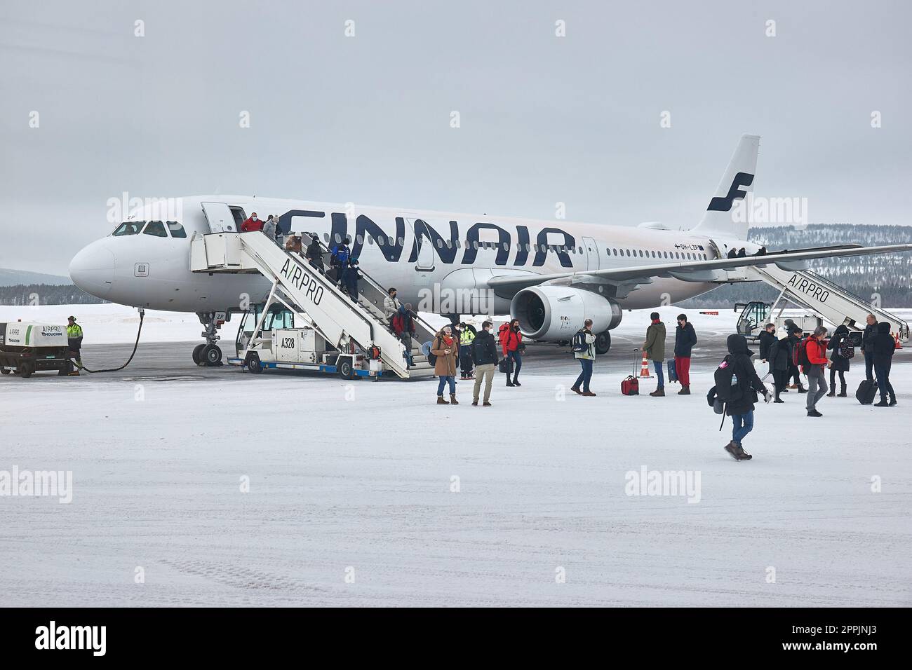 Finnair airplane passengers exiting on snow upon arrival Stock Photo ...