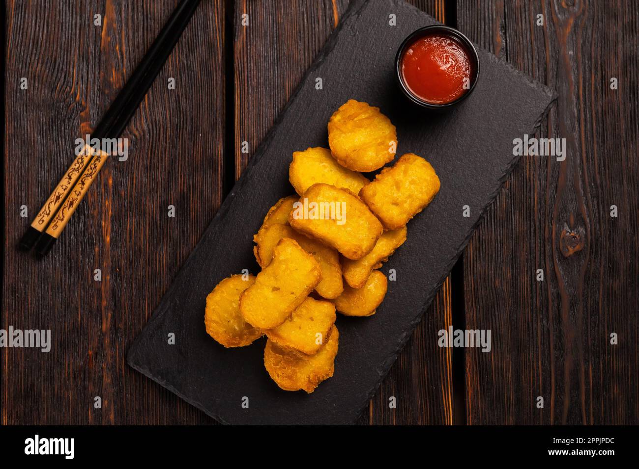 Fried chicken pieces on stone board with chopsticks - asian food top ...