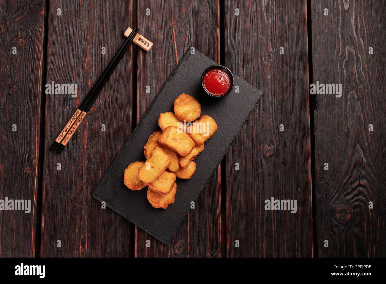 Fried chicken pieces on stone board with chopsticks - asian food top ...