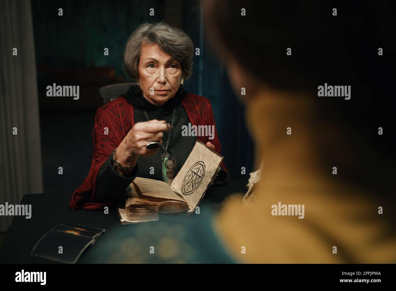 Mature witch spell for client using witchcraft book and magic pendulum ...