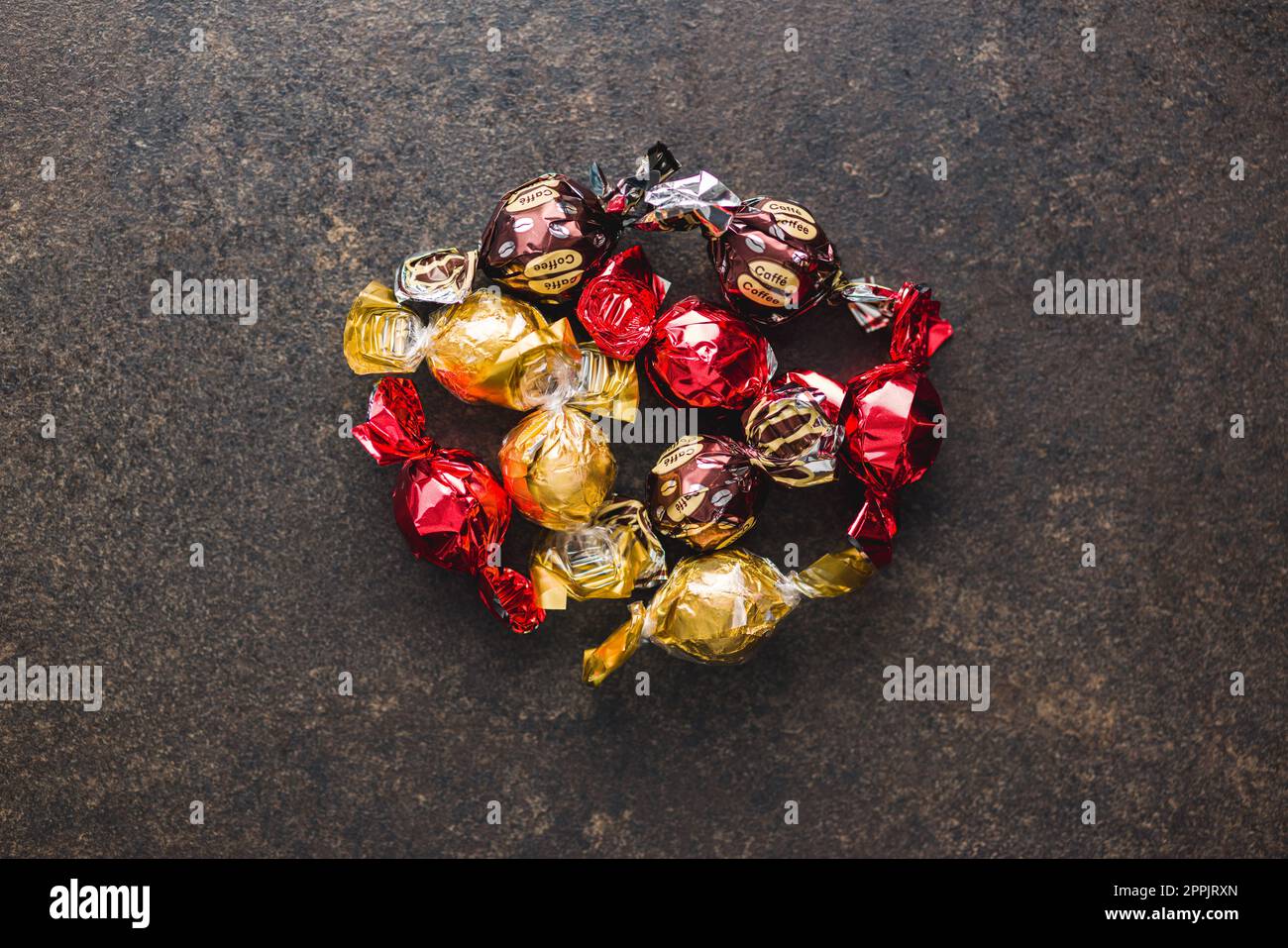Sweet candy wrapped in foil on kitchen table. Top view Stock Photo - Alamy