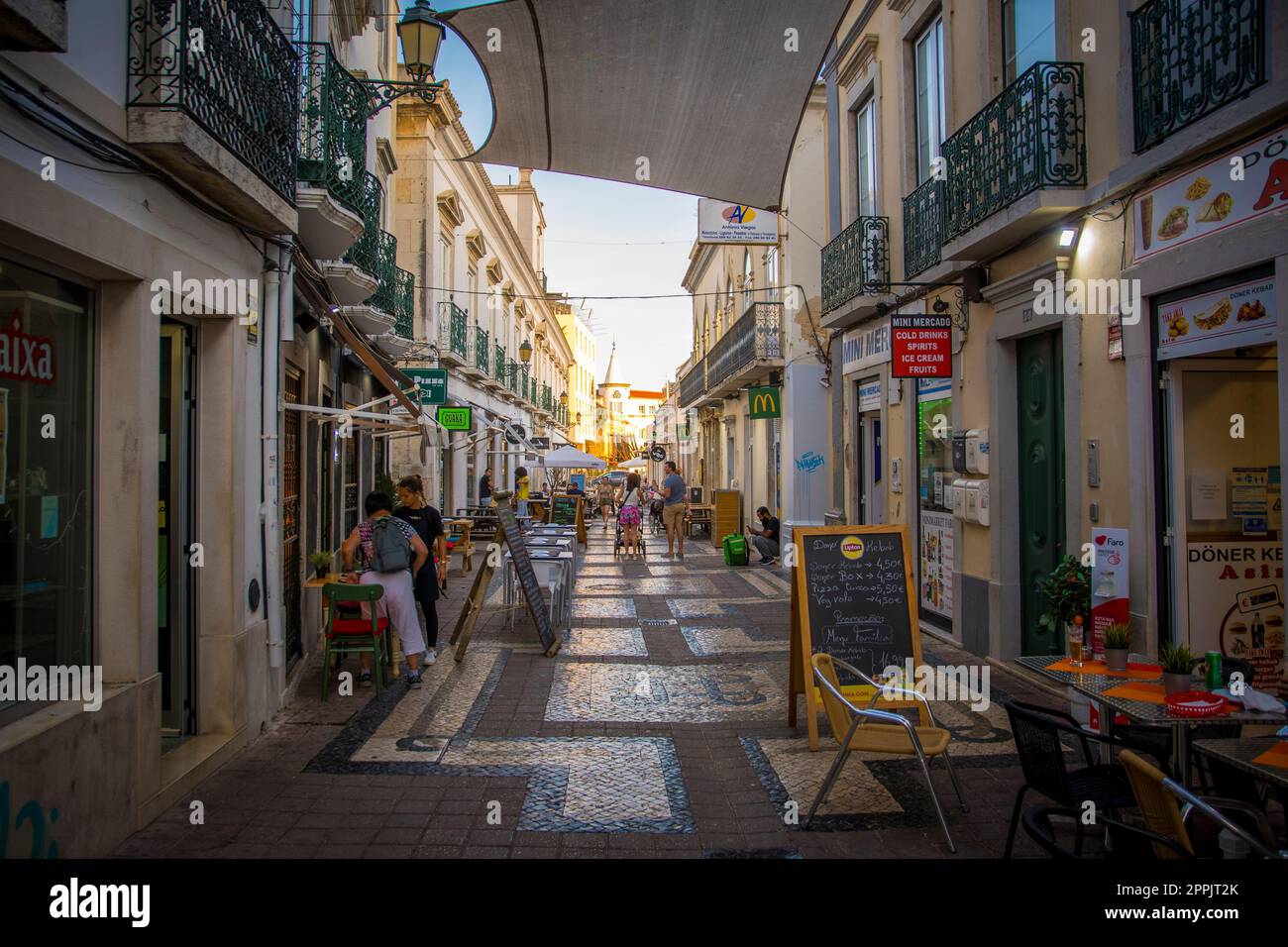 View on a cozy street with restaurants and bars in the old town of Faro ...