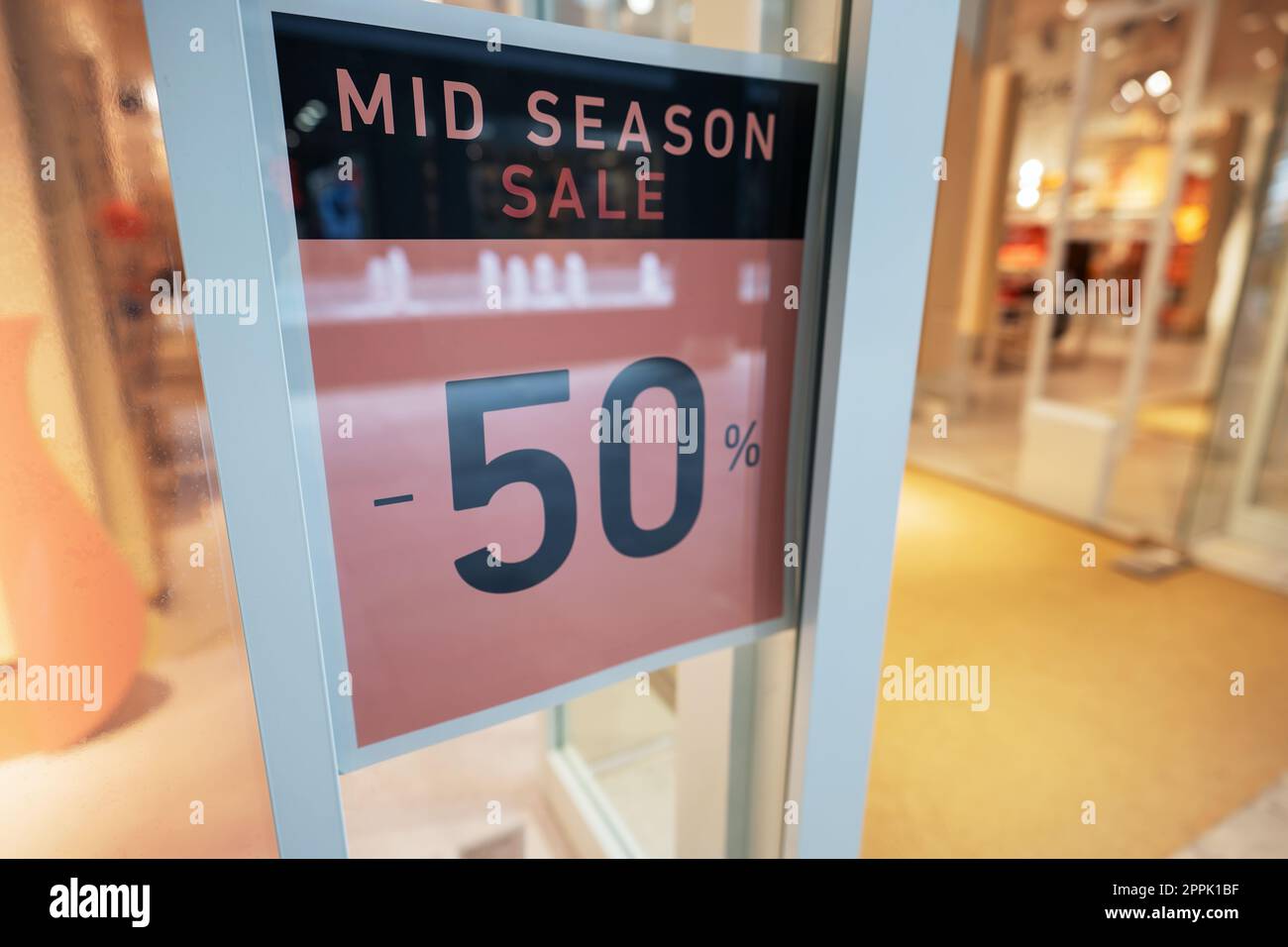 Shop window in shopping center with "Mid Season Sale" poster Stock ...