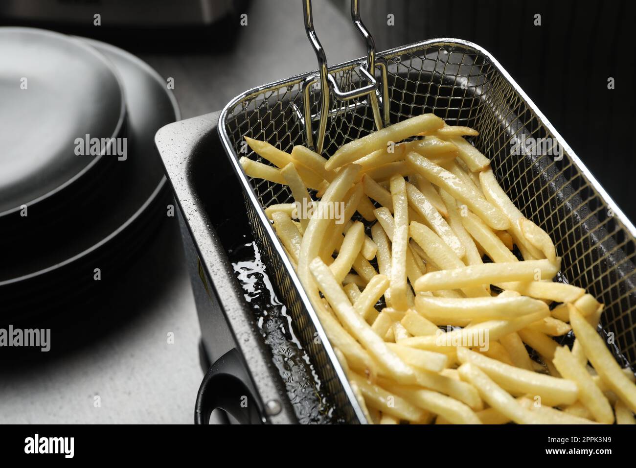 Cooking delicious french fries in hot oil, closeup Stock Photo - Alamy