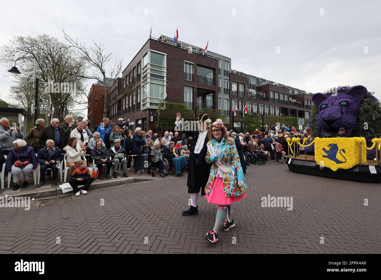 An attractive couple wearing colorful costumes stand in front of a ...