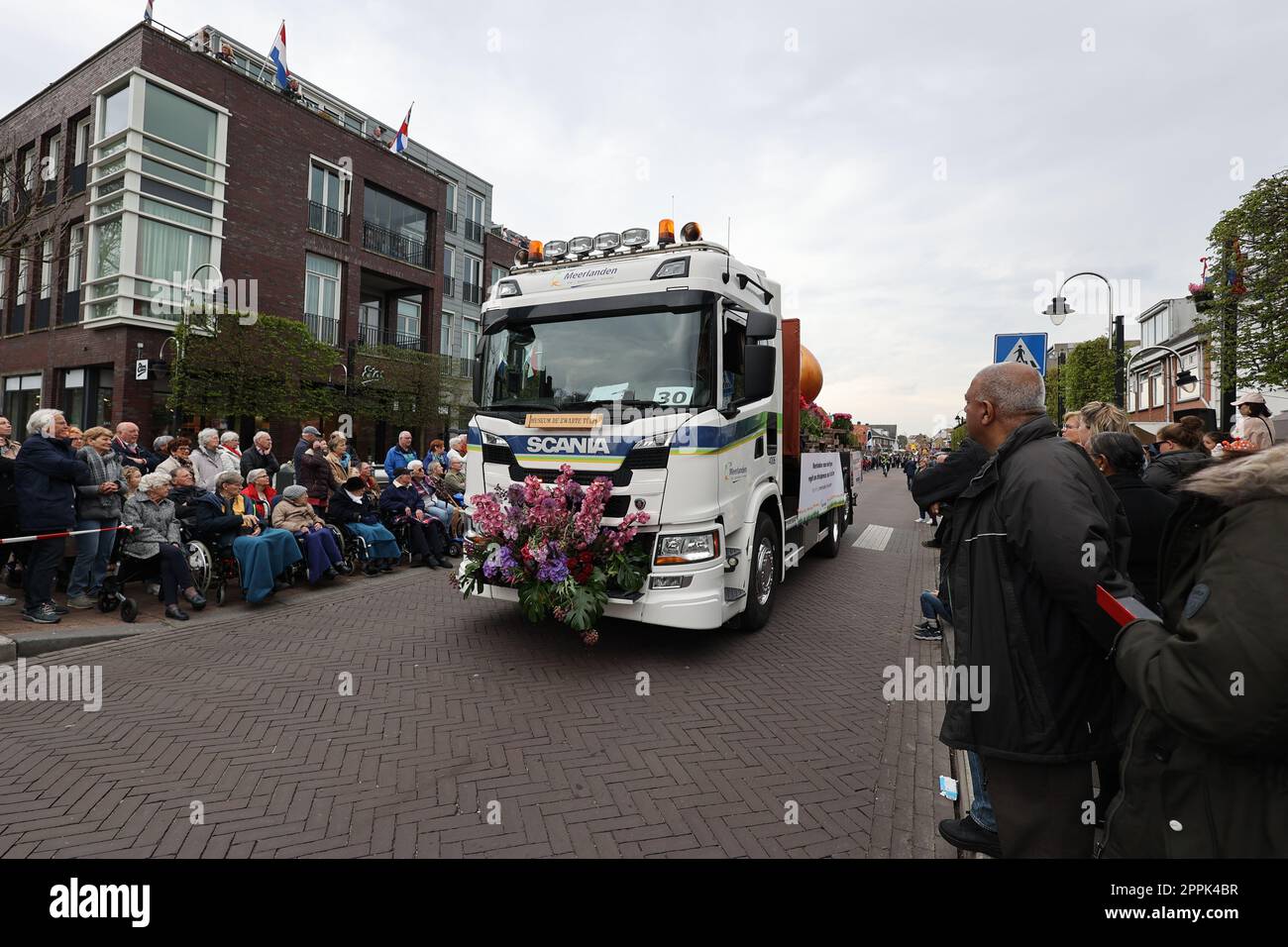A group of diverse people enjoying an outdoor parade, looking up in awe ...