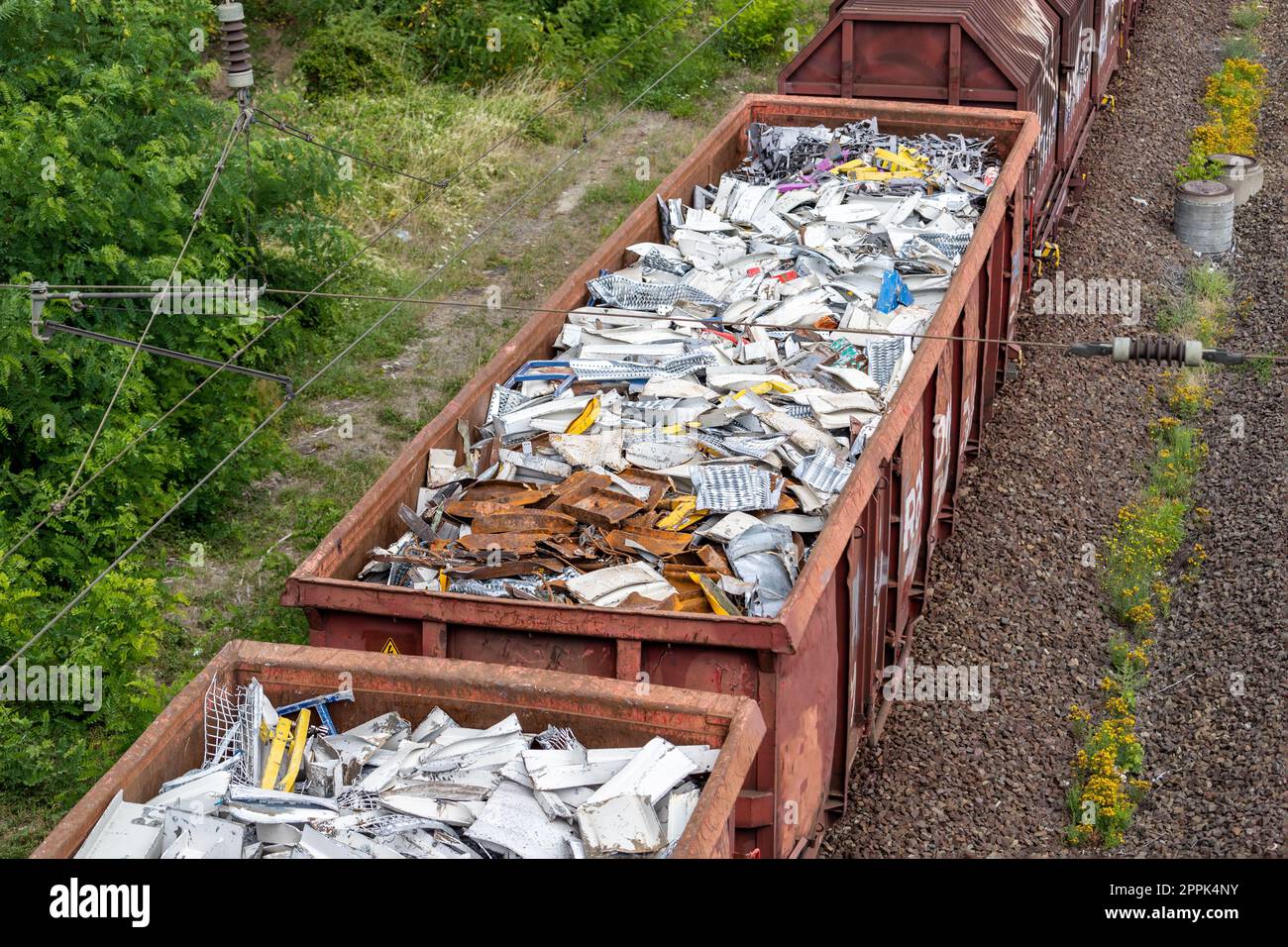 Above view of railway cargo train wagon filled by old rusty black metal ...