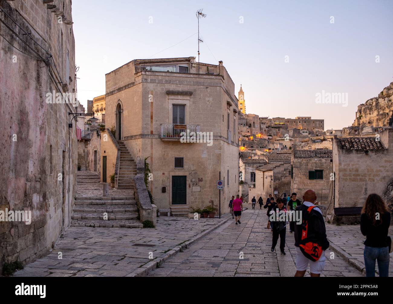 Tourists during a walk on Cobblestone street in the Sassi di Matera a ...