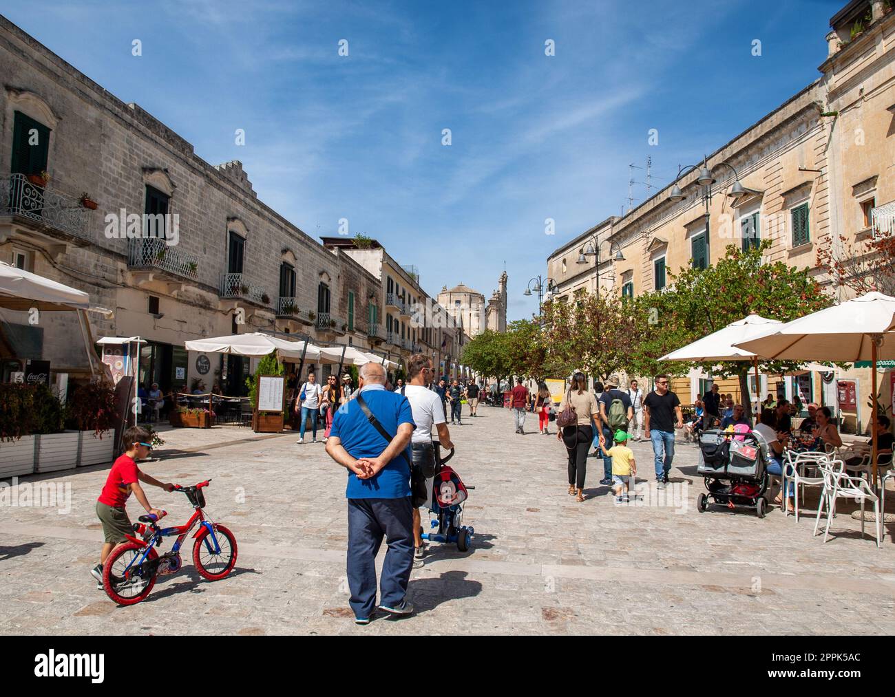 Tourists during a walk on Cobblestone street in the Sassi di Matera a ...