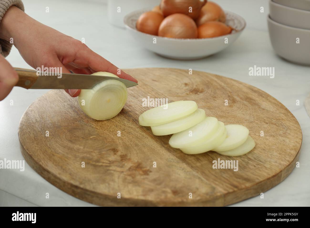 Woman cutting white onion into rings at countertop, closeup Stock Photo ...