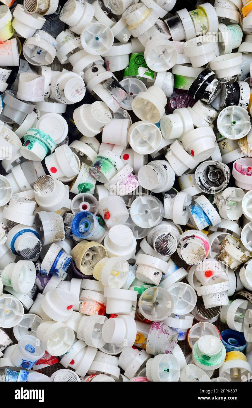 A large number of caps from cans of aerosol paint for graffiti. Smeared ...