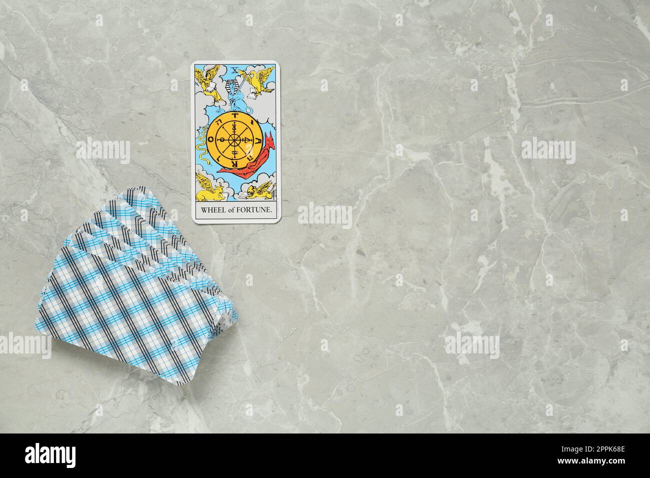 The Wheel of Fortune and other tarot cards on light grey marble table ...